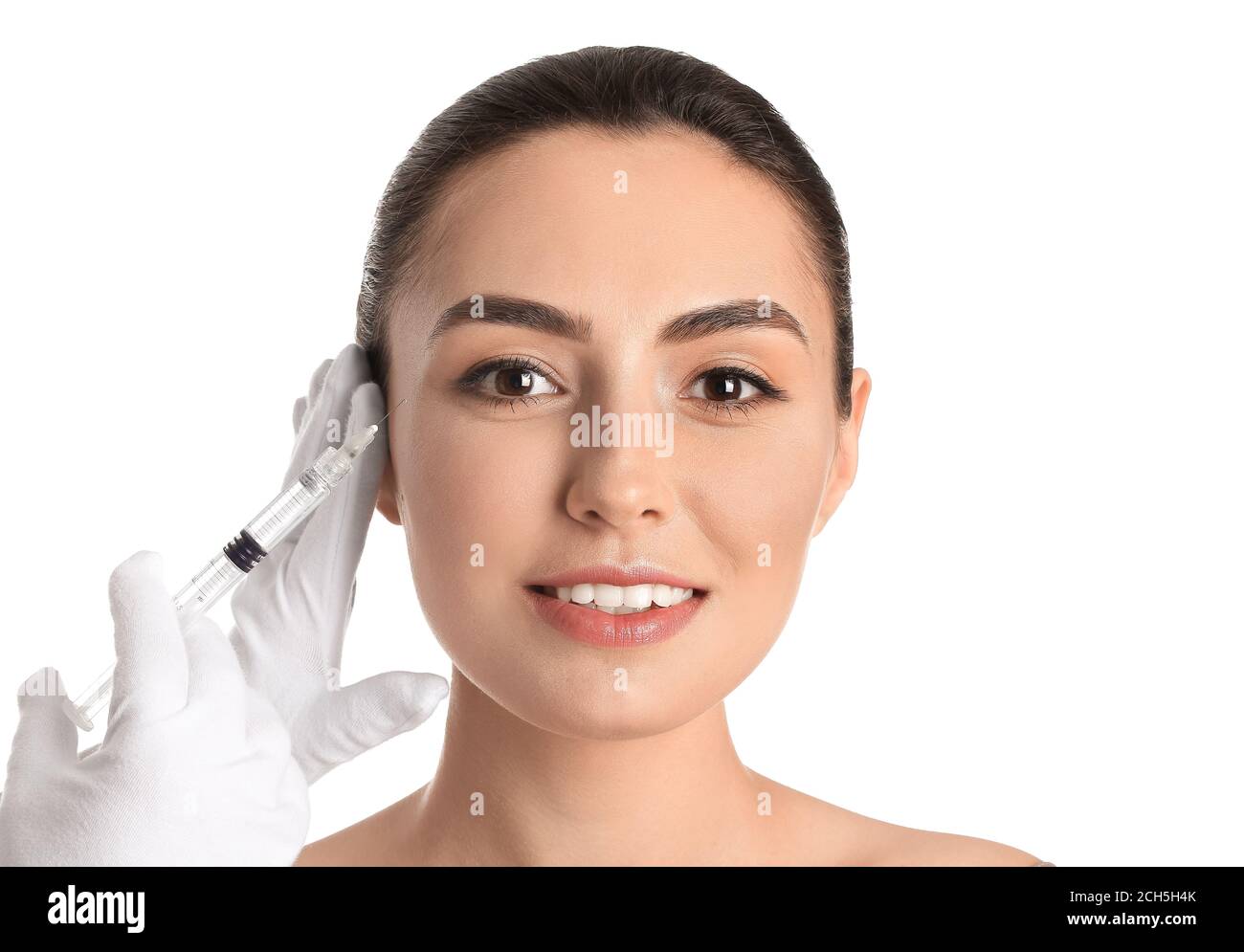 Beautiful young woman receiving injection of filler on white background ...