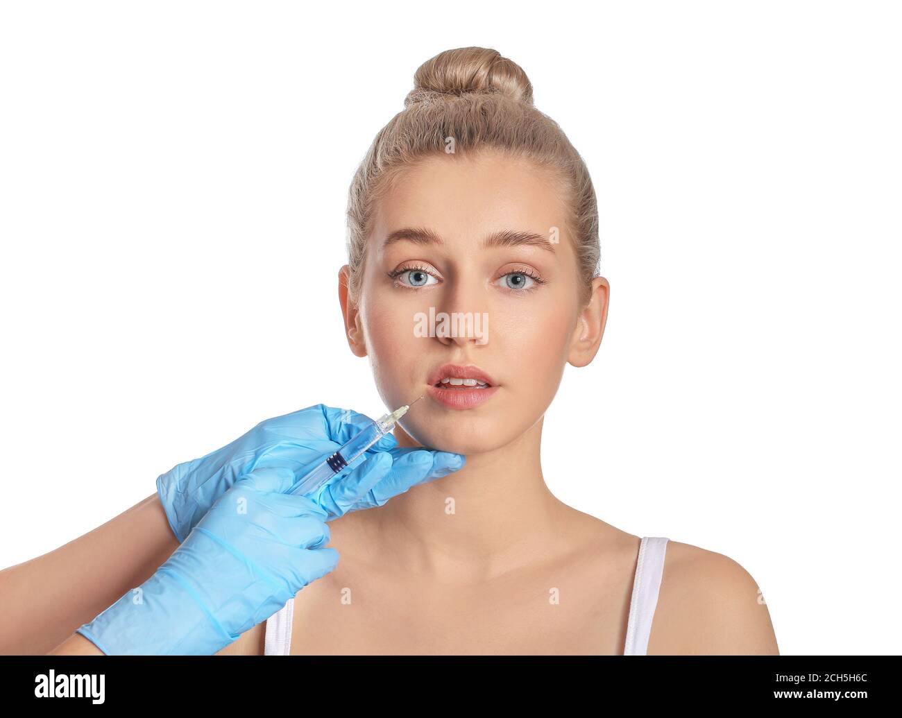 Beautiful young woman receiving injection of filler on white background ...