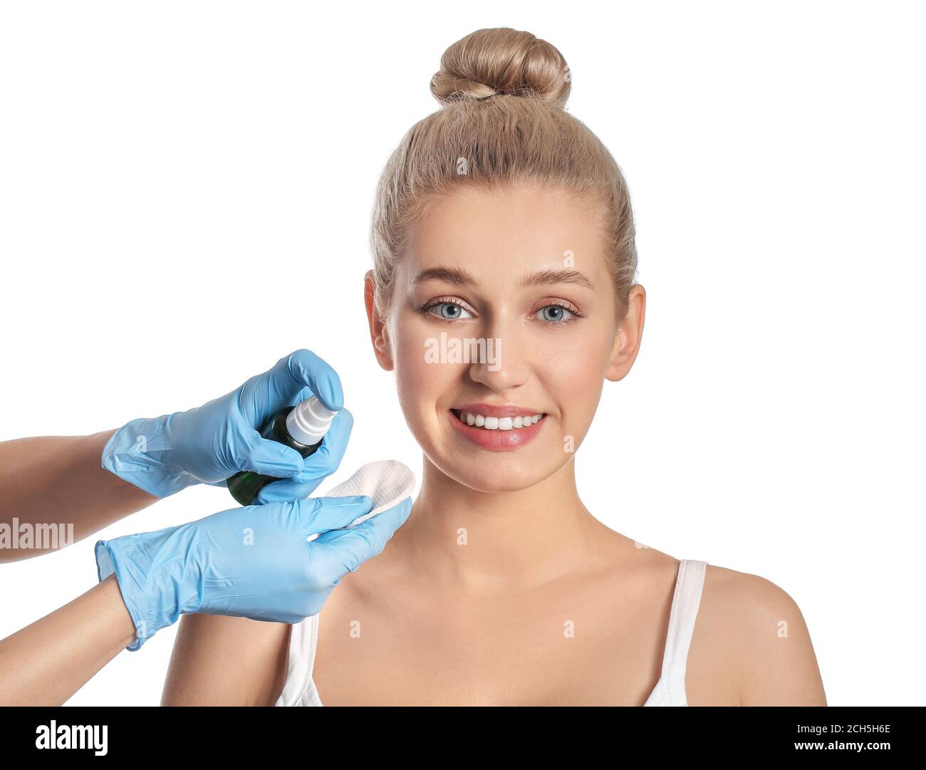 Beautician applying cosmetics on woman's face against white background ...