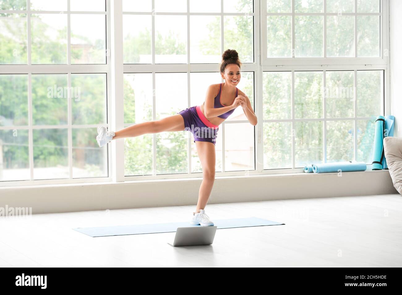 Sporty young woman with laptop training at home Stock Photo - Alamy