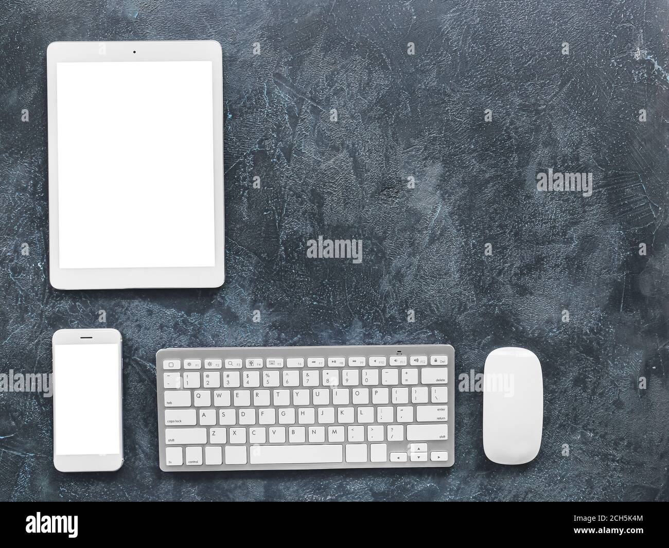 Modern tablet computer, PC keyboard, mouse and smartphone on table ...