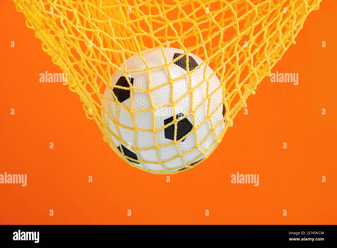 Soccer ball in net on color background Stock Photo - Alamy