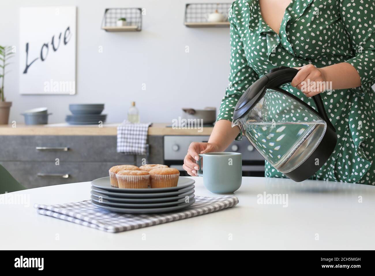 Woman making tea in kitchen Stock Photo - Alamy