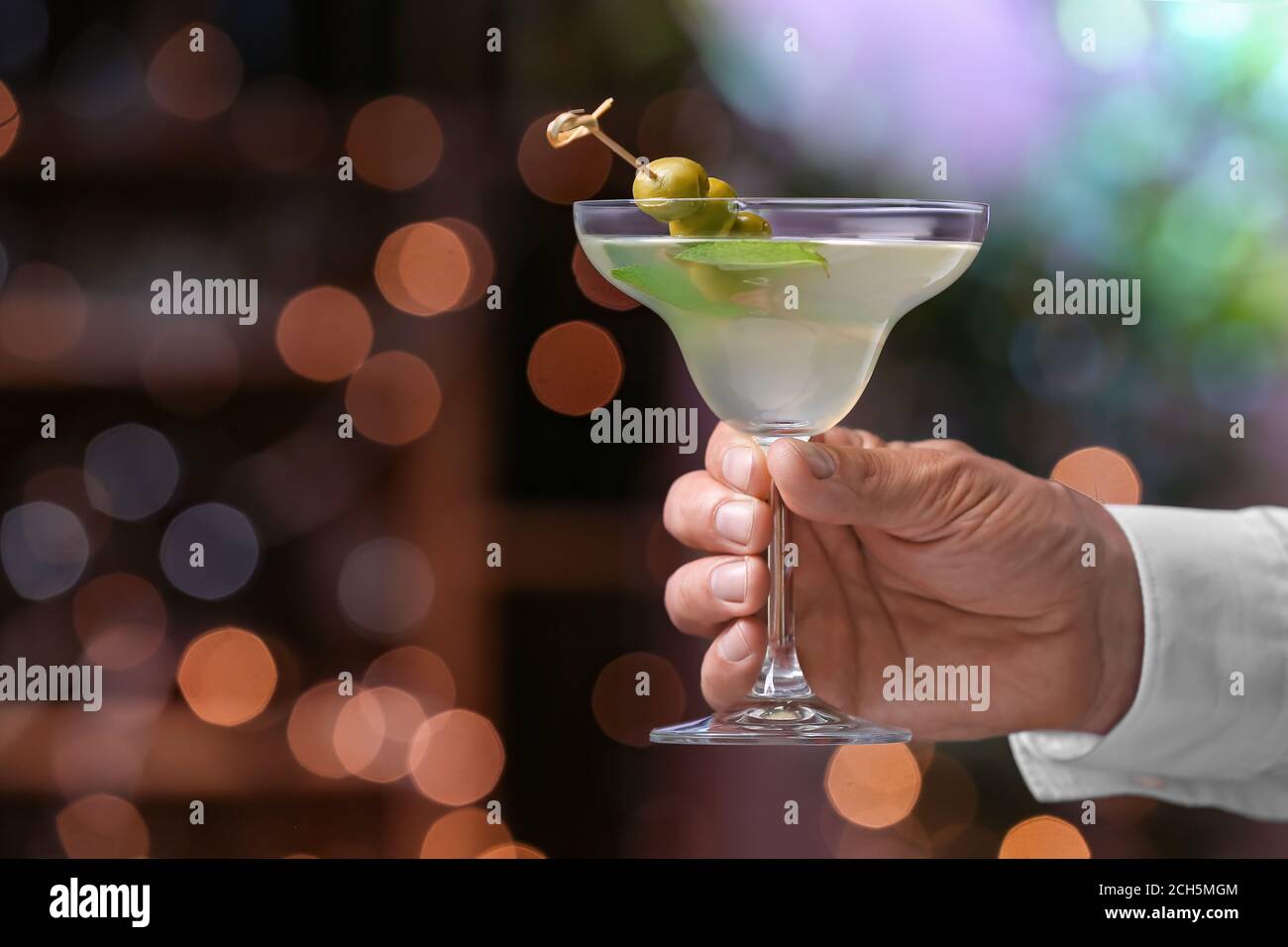 Man with glass of fresh martini in pub Stock Photo - Alamy