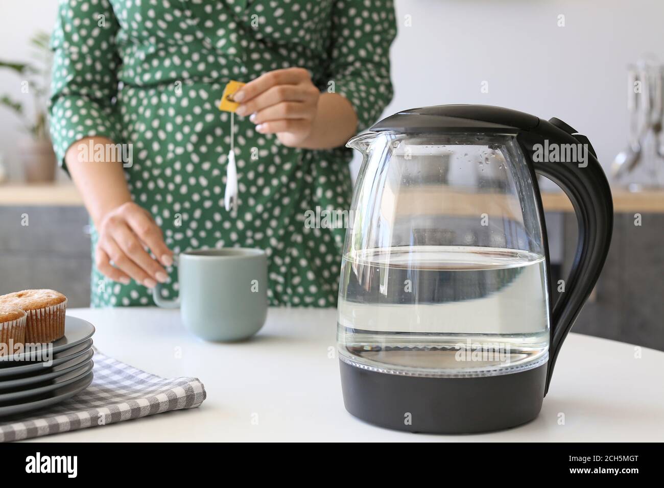 Woman making tea in kitchen Stock Photo - Alamy