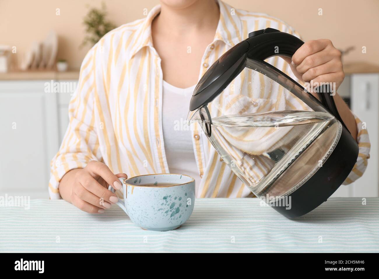 Woman making tea in kitchen Stock Photo - Alamy