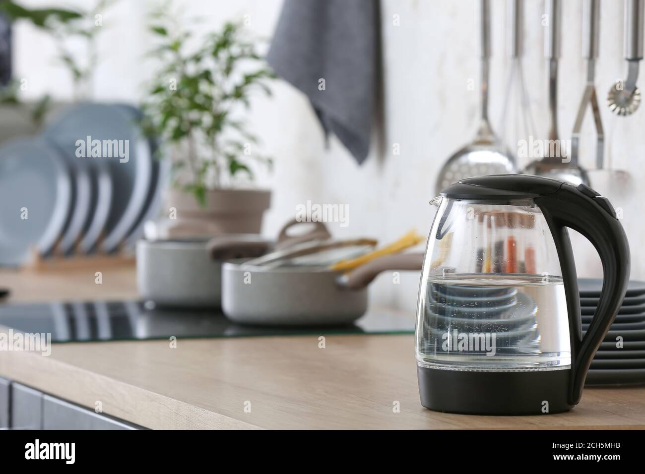 Modern electric kettle on kitchen counter Stock Photo - Alamy