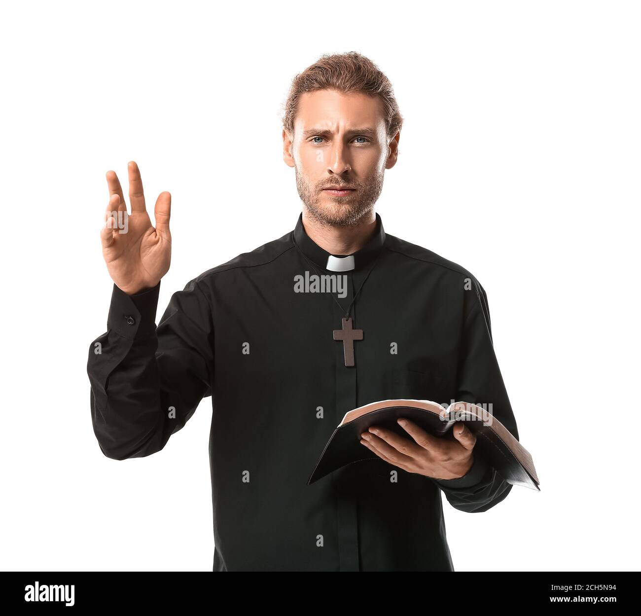 Handsome priest with Bible on white background Stock Photo - Alamy
