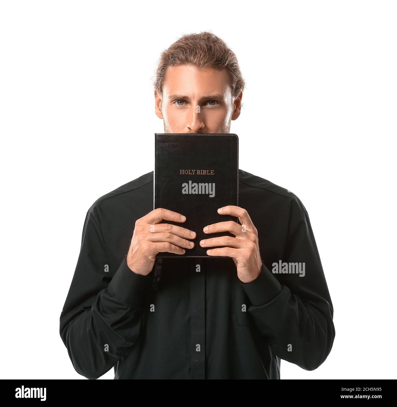 Handsome priest with Bible on white background Stock Photo - Alamy