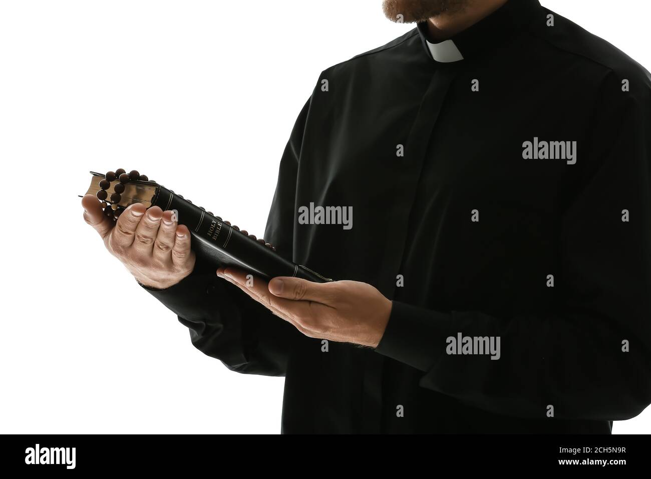 Handsome priest with Bible on white background Stock Photo - Alamy