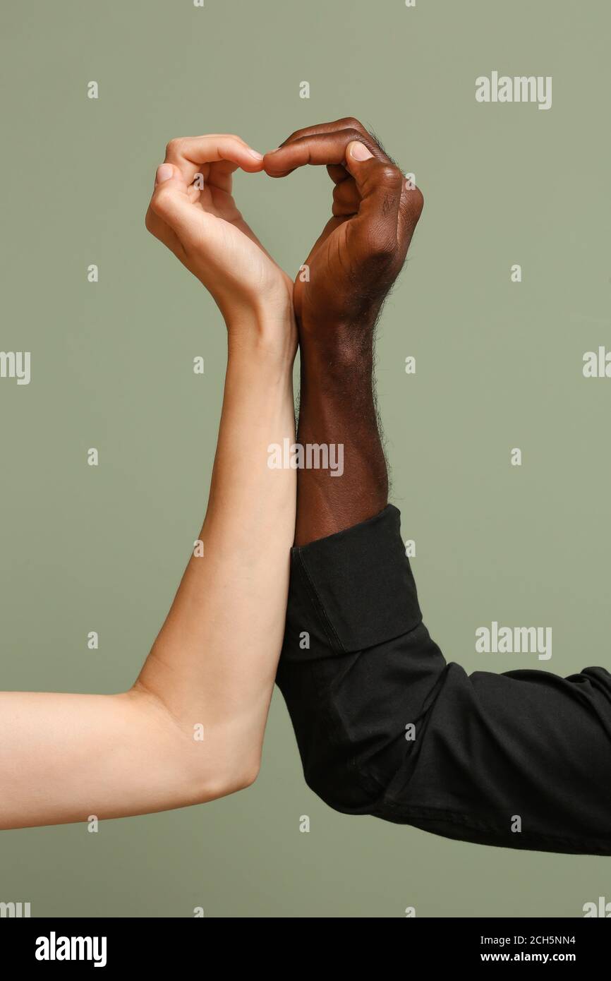 Caucasian woman and African-American man making heart with their hands ...