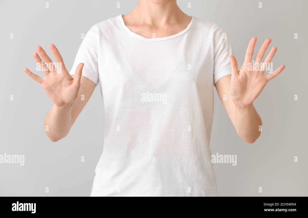 Young deaf mute woman using sign language on grey background Stock ...