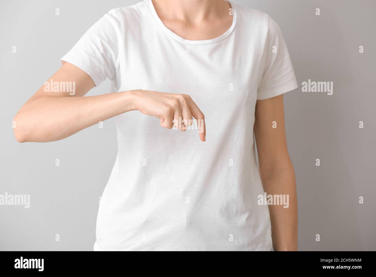 Young deaf mute woman using sign language on grey background Stock ...