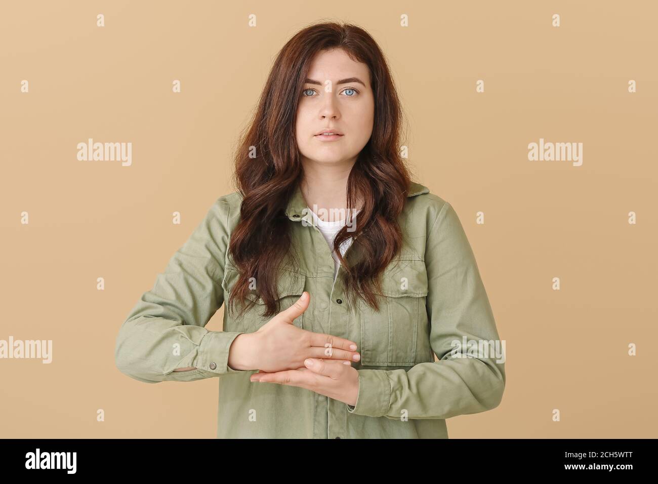 Young deaf mute woman using sign language on color background Stock ...