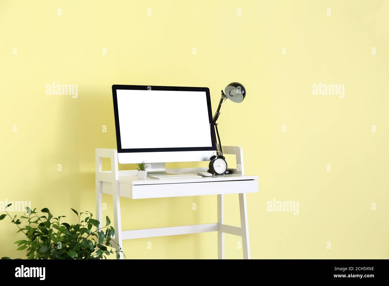 Modern PC monitor on table near color wall Stock Photo - Alamy