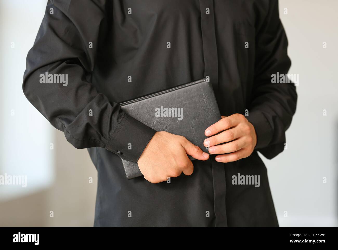 Male priest with Bible at home Stock Photo - Alamy