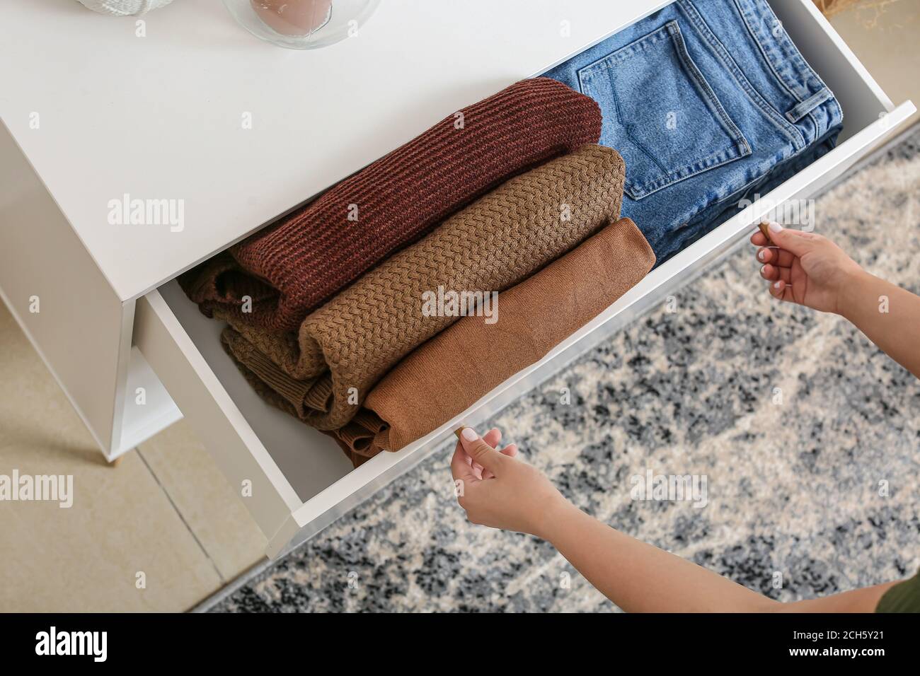 Woman opening drawer with clothes at home Stock Photo - Alamy