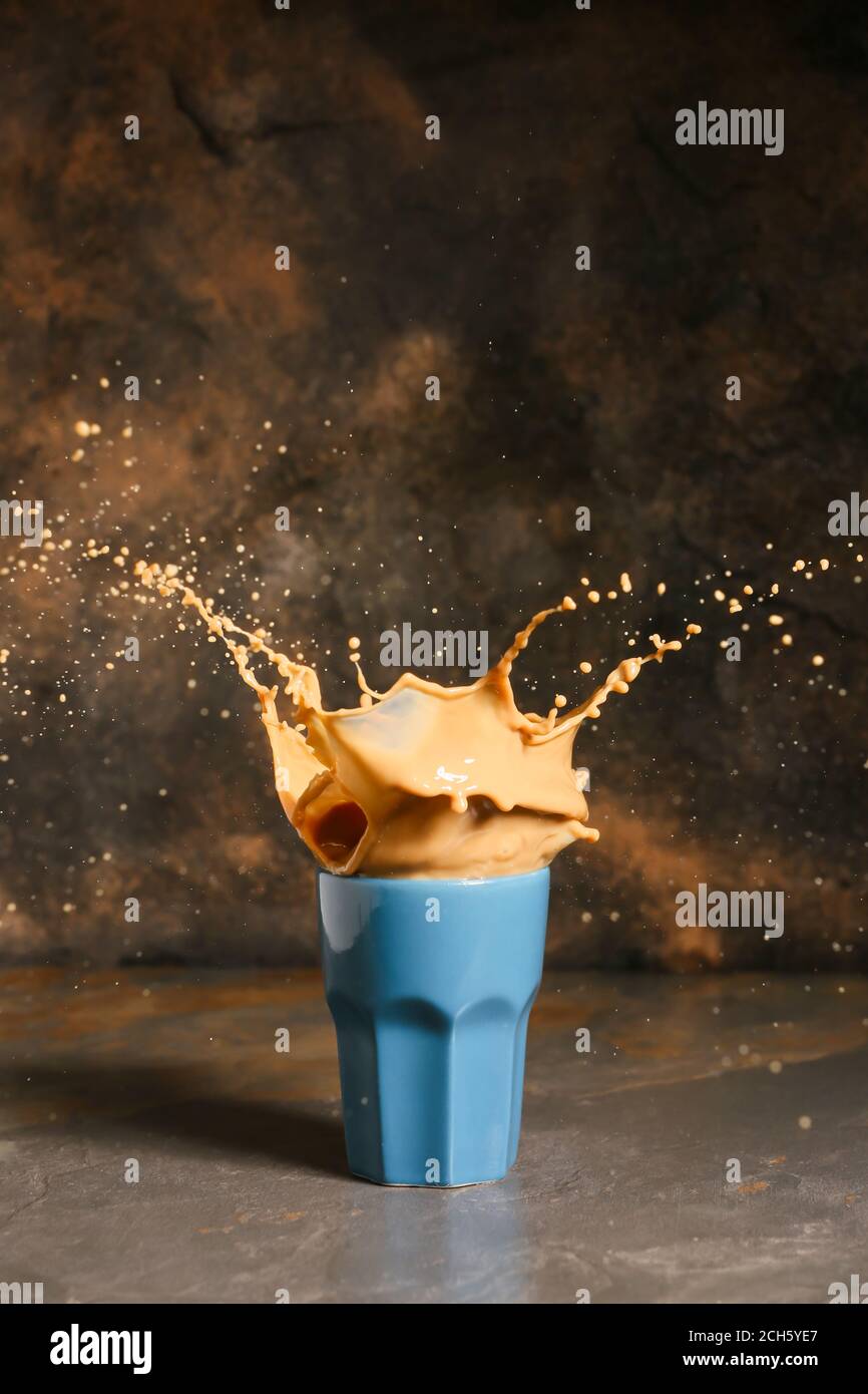 Cup of hot coffee with splash on table Stock Photo - Alamy