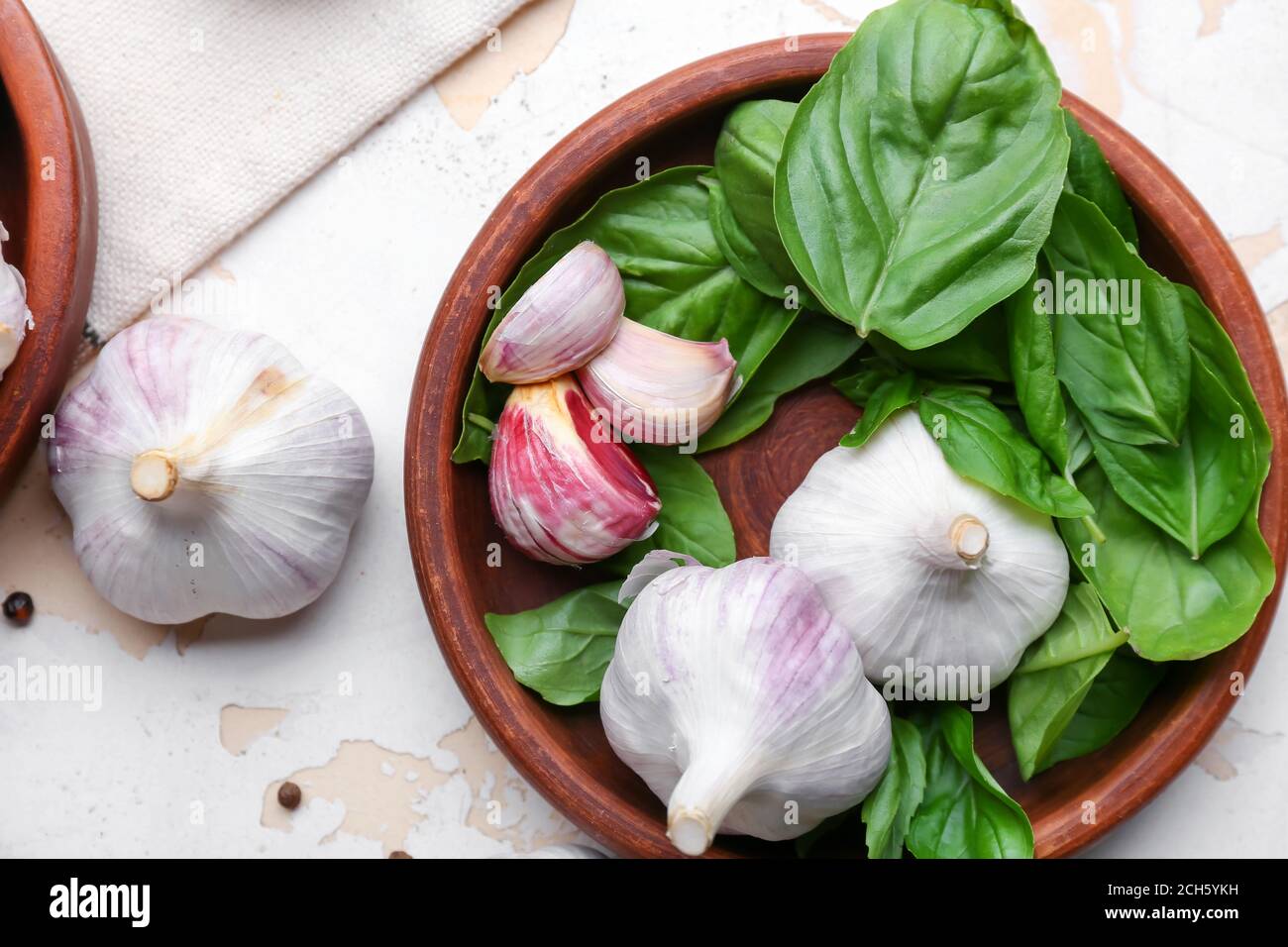 Plate with fresh garlic and basil on light background Stock Photo - Alamy