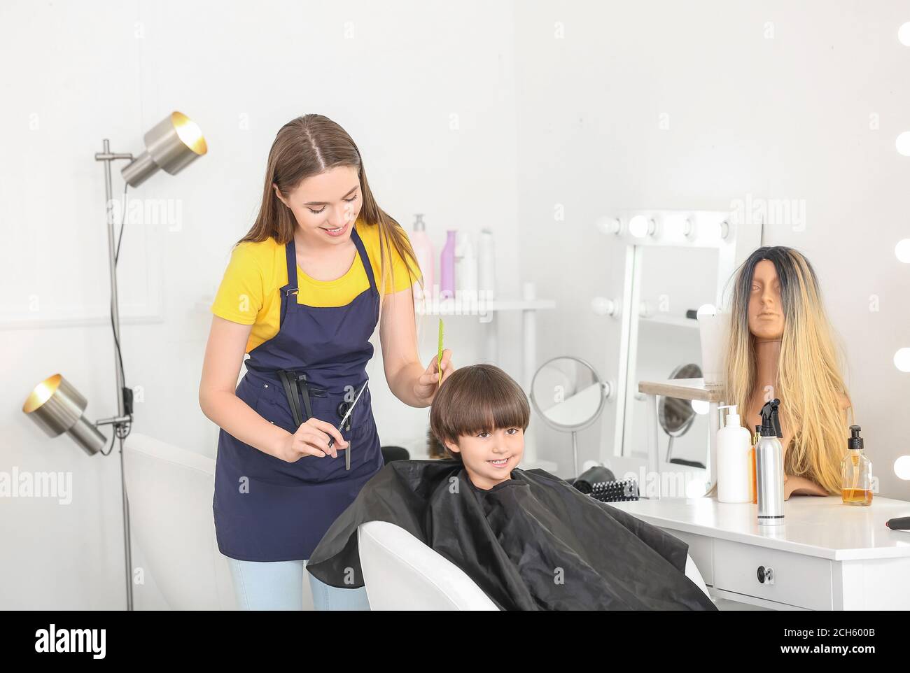 Female hairdresser working with little boy in salon Stock Photo - Alamy