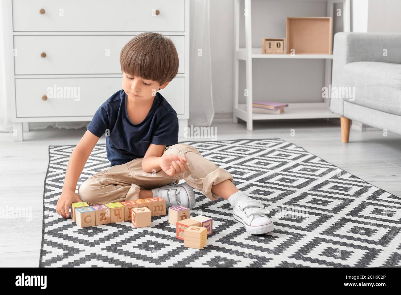 Little boy with autistic disorder playing with cubes at home Stock ...