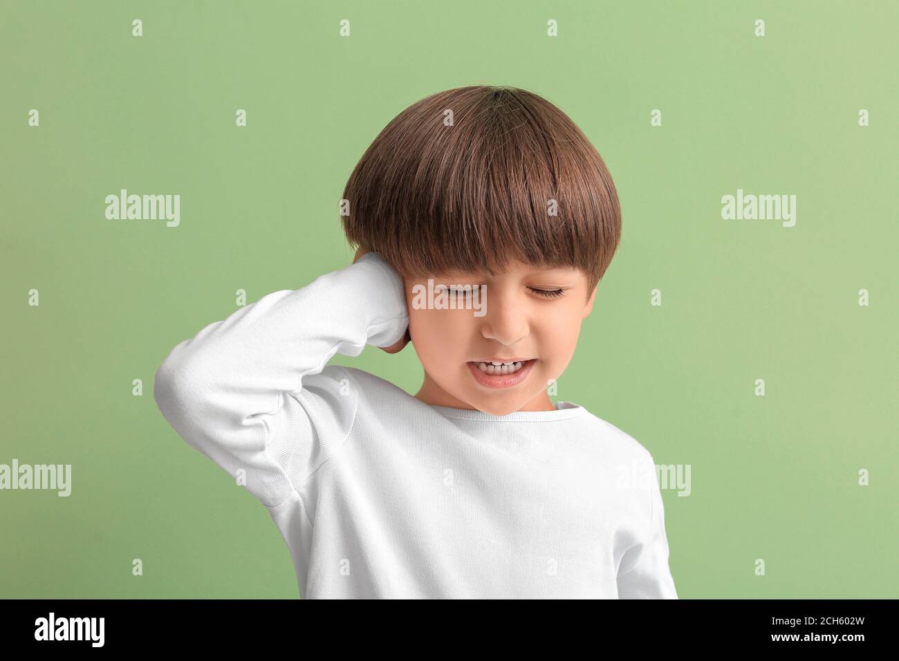 Little boy suffering from ear pain on color background Stock Photo - Alamy