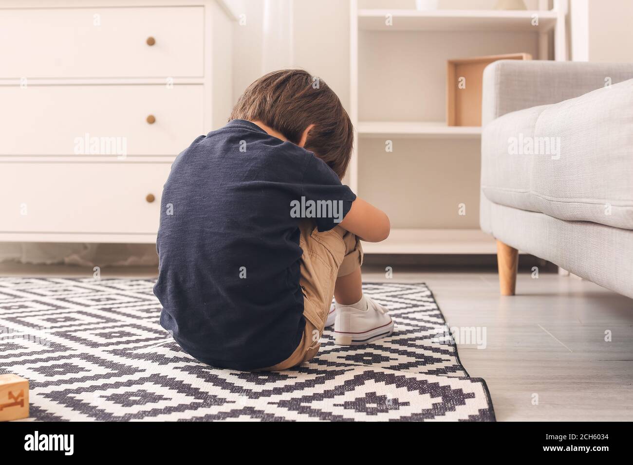 Sad little boy with autistic disorder at home Stock Photo - Alamy