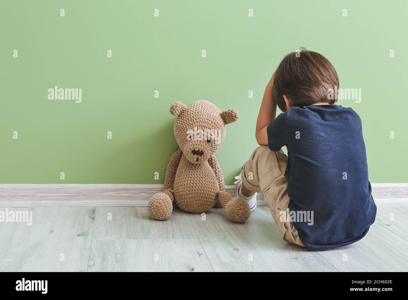 Sad little boy with autistic disorder near color wall Stock Photo - Alamy