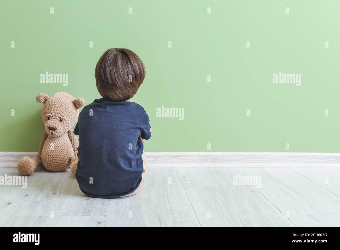 Sad little boy with autistic disorder near color wall Stock Photo - Alamy