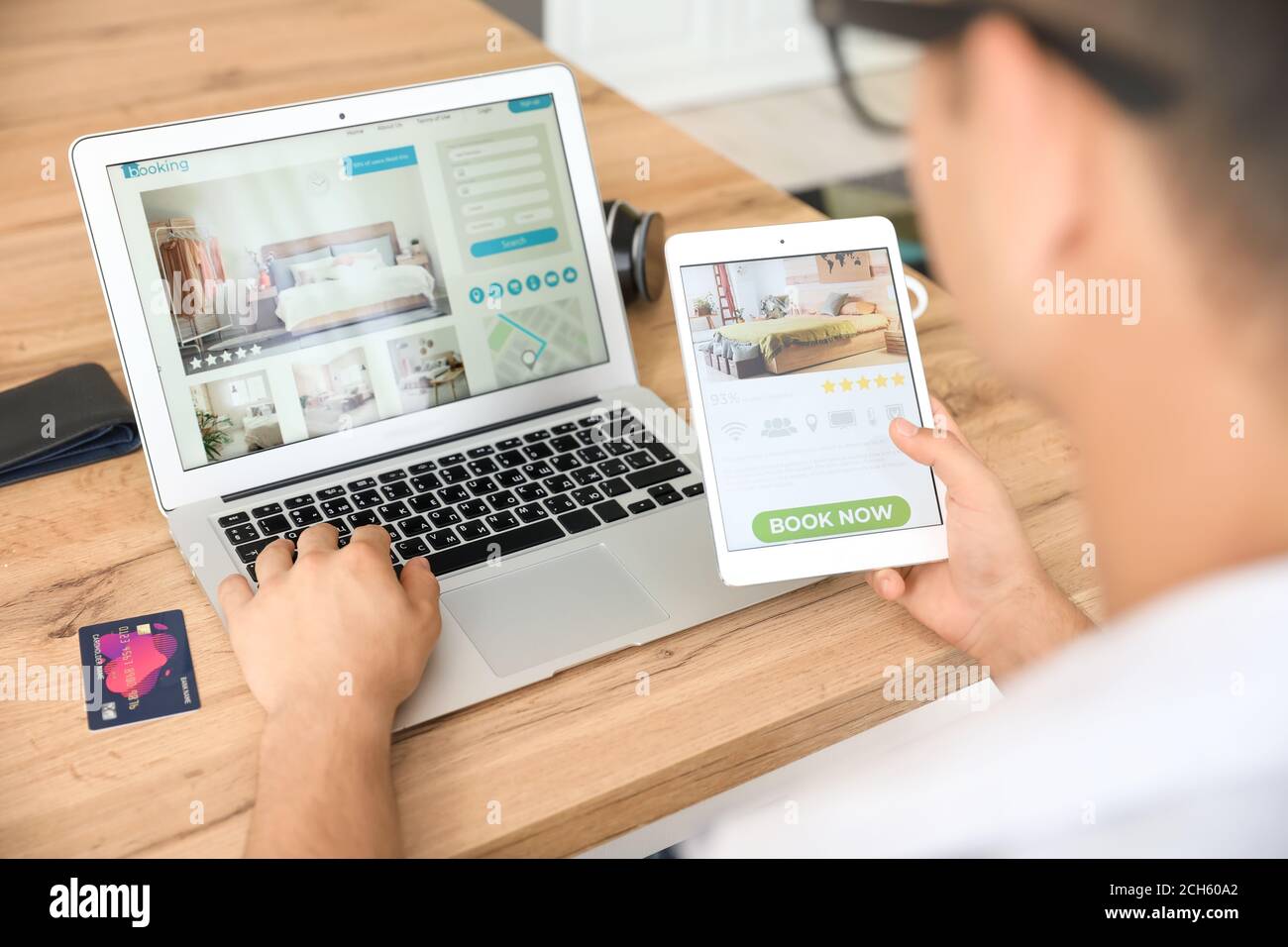 Man with tablet computer booking room in hotel online at home Stock ...