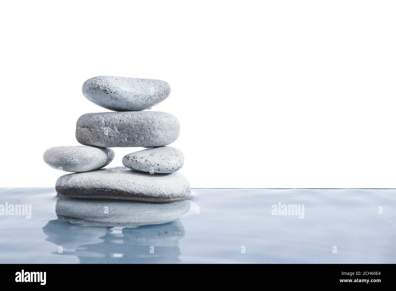 Stack of spa stones in water on white background Stock Photo - Alamy