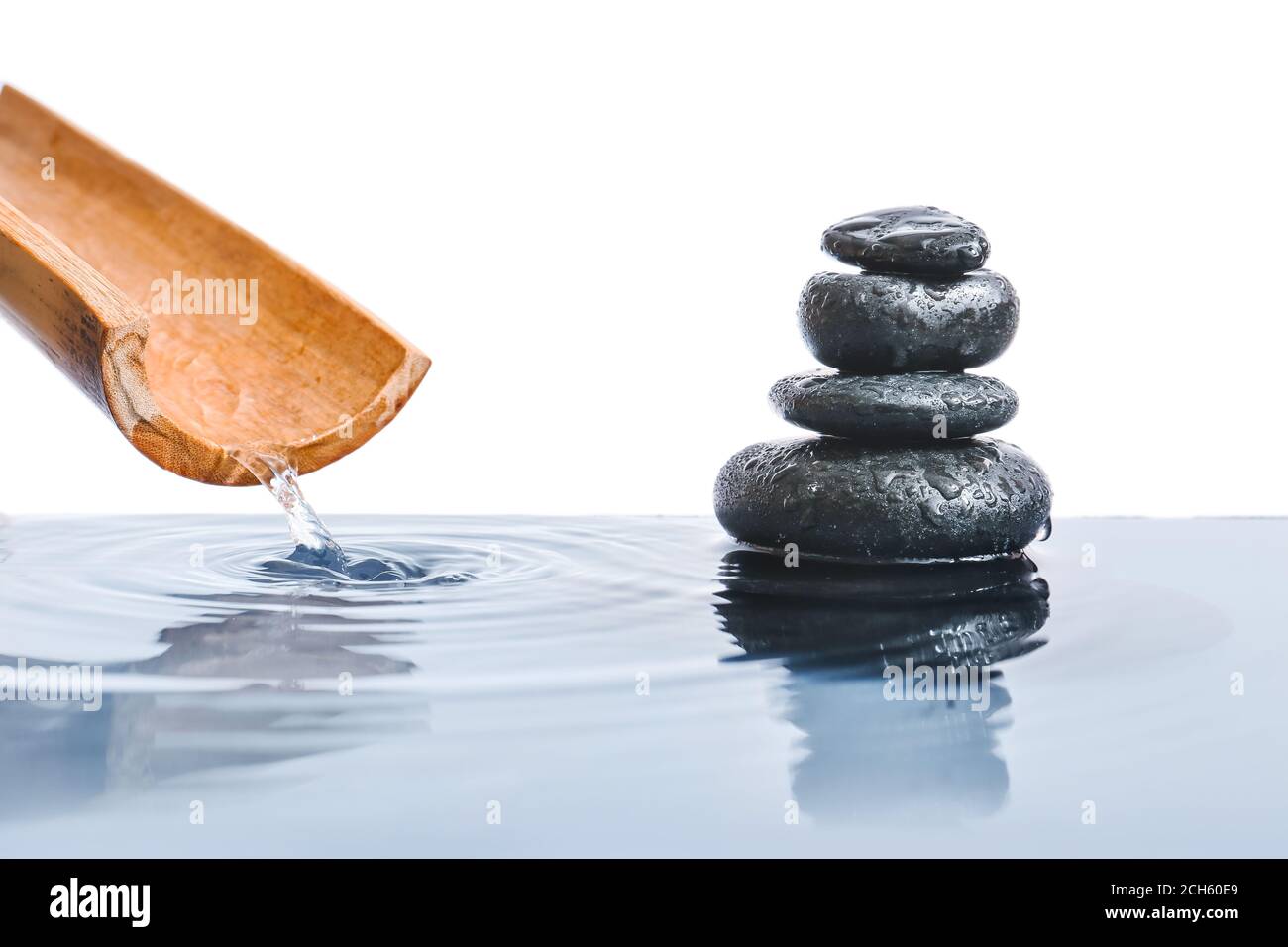 Stack of spa stones in water on white background Stock Photo - Alamy