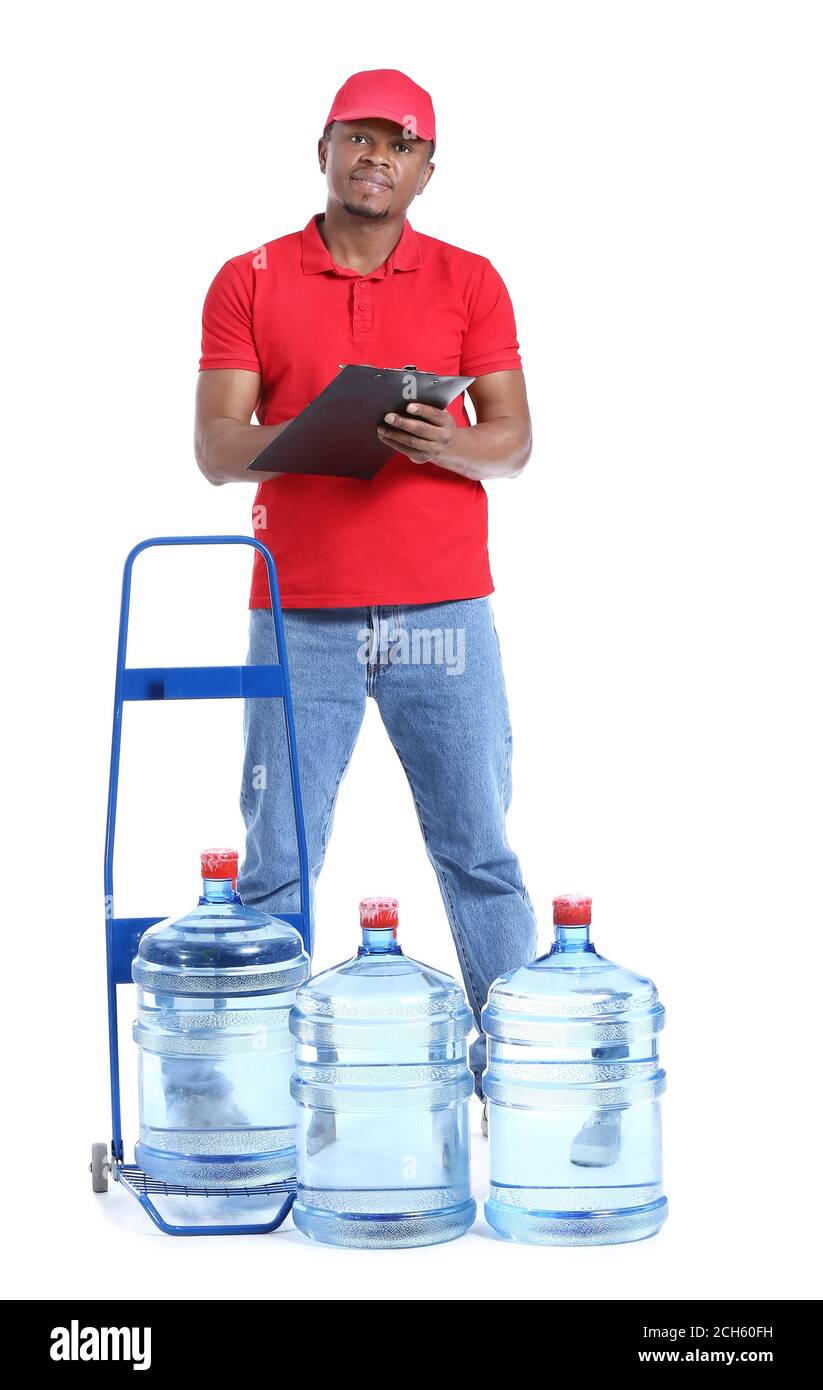 African-American delivery man with bottles of water on white background ...