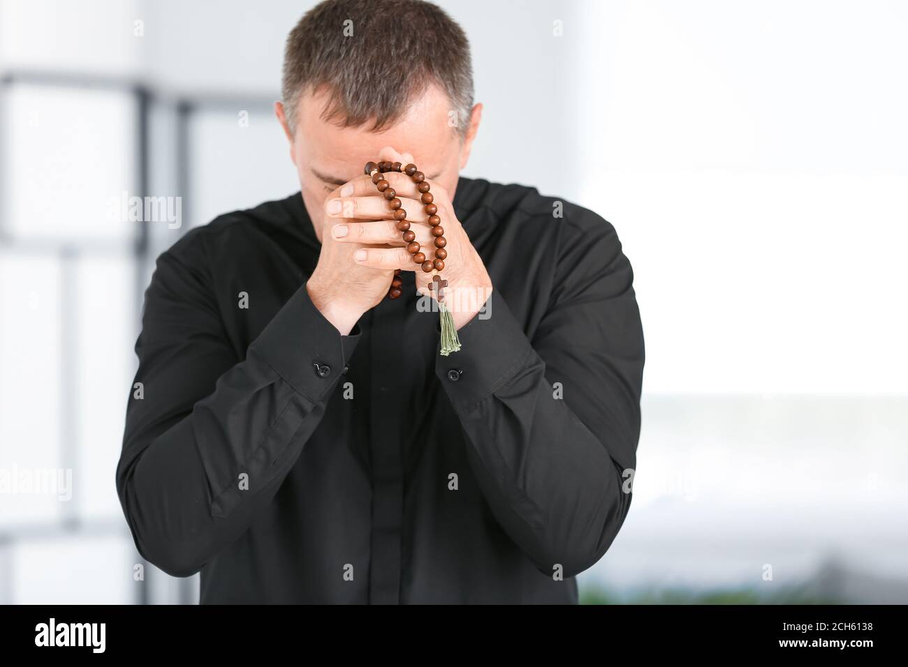 Portrait of praying male priest at home Stock Photo - Alamy