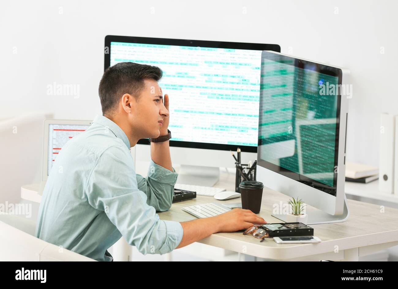 Stressed male programmer working in office Stock Photo - Alamy
