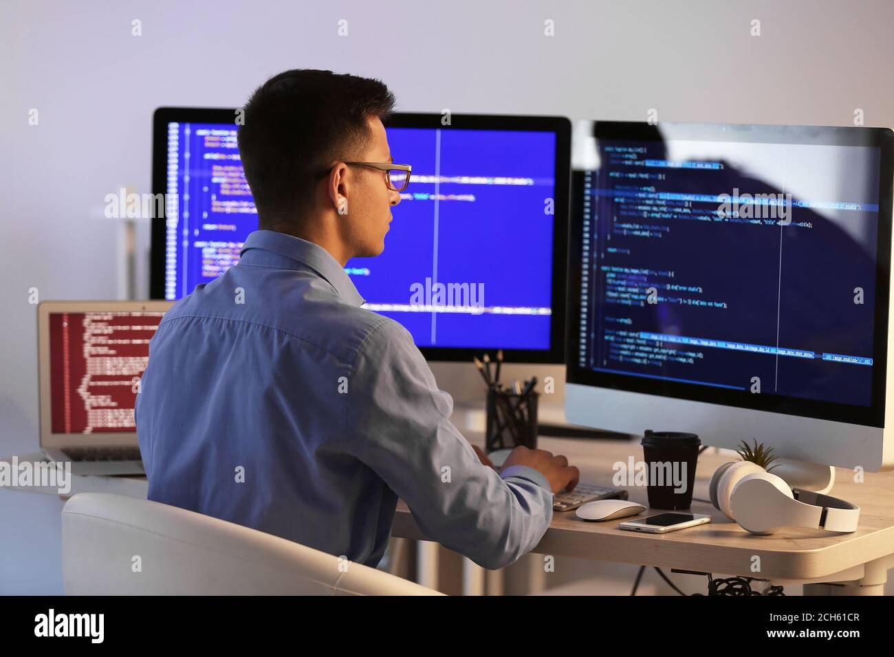 Male programmer working in office at night Stock Photo - Alamy