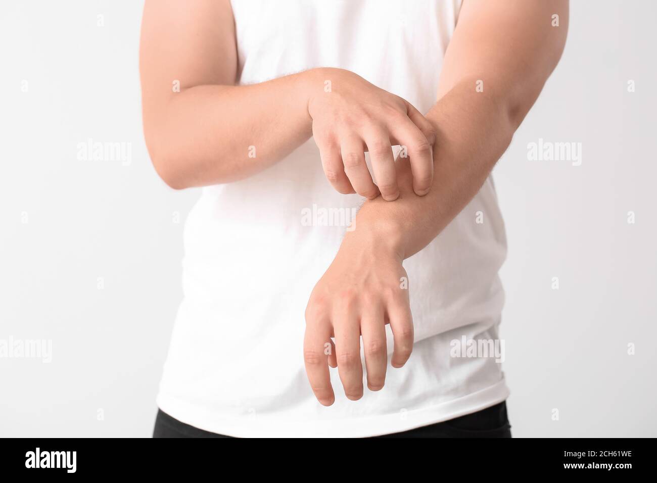 Teenage boy suffering from itching on light background Stock Photo - Alamy