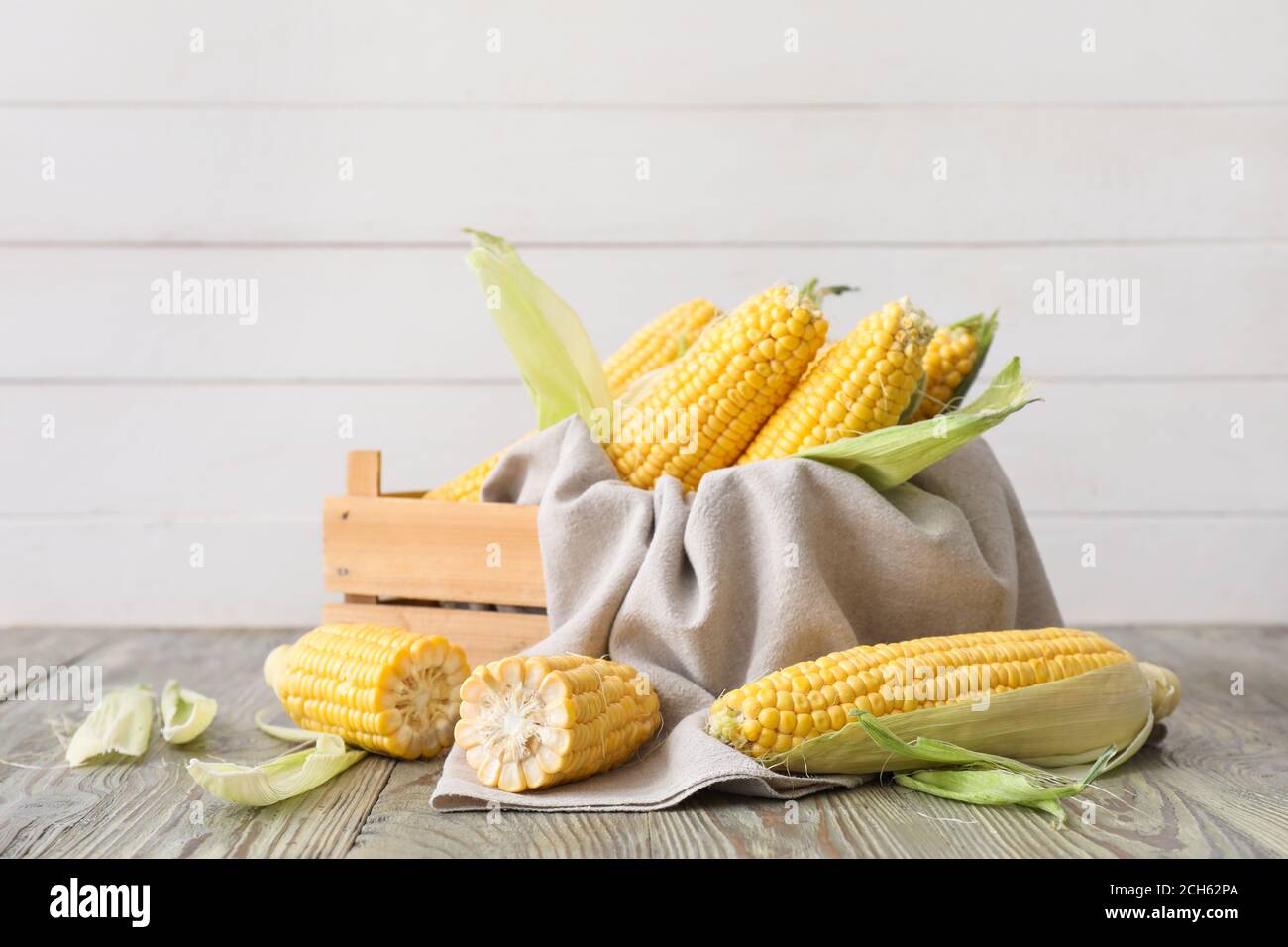 Box with fresh corn cobs on table Stock Photo - Alamy