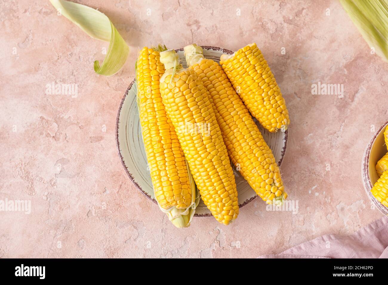 Plate with fresh corn cobs on color background Stock Photo - Alamy