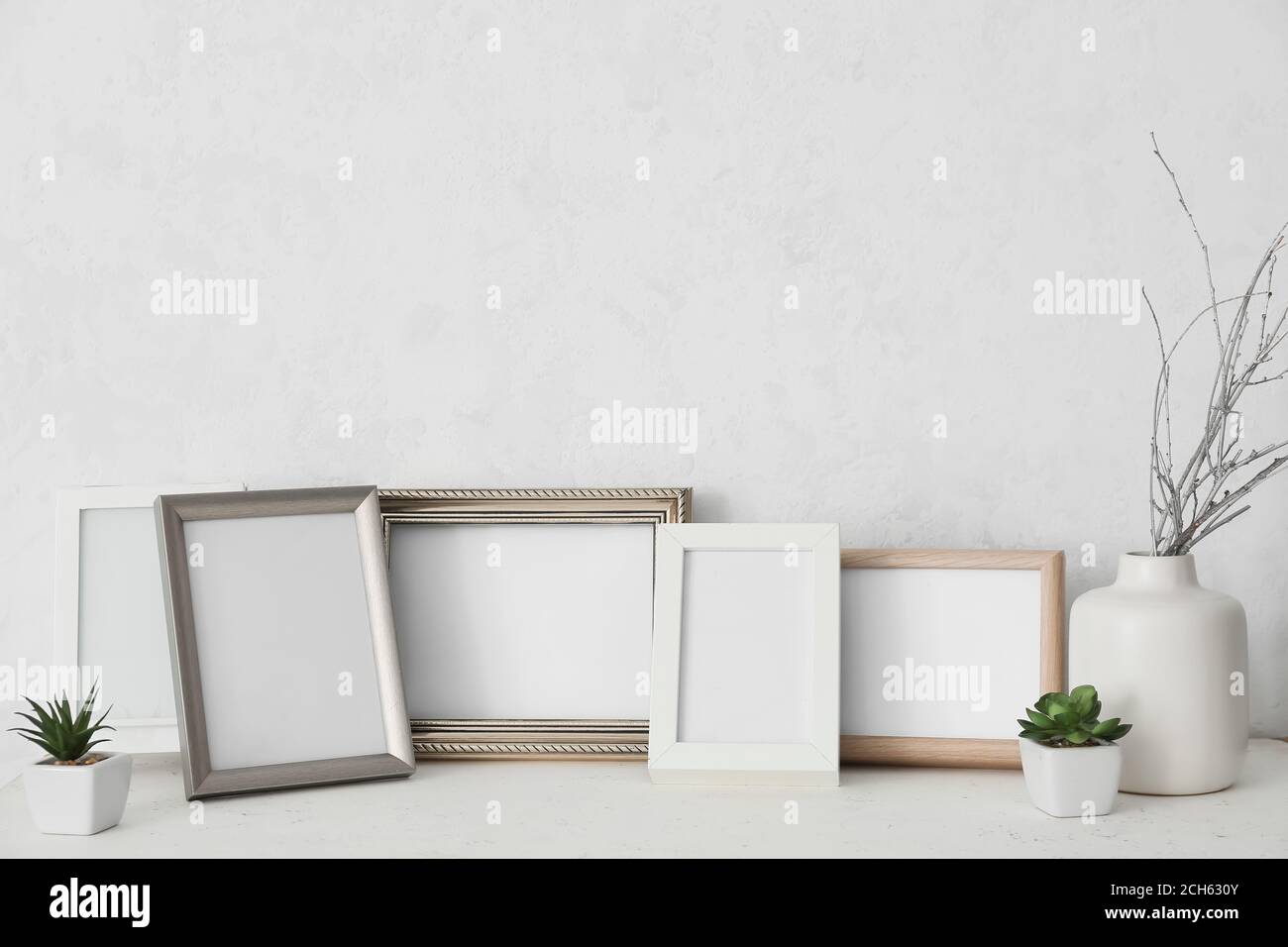 Photo frames on table in room Stock Photo - Alamy