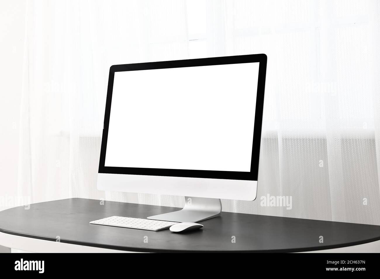 Modern PC monitor on table near window Stock Photo - Alamy