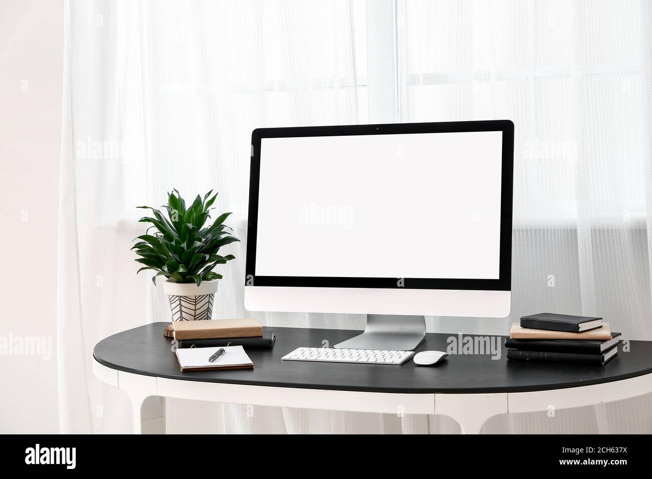 Modern PC monitor on table near window Stock Photo - Alamy