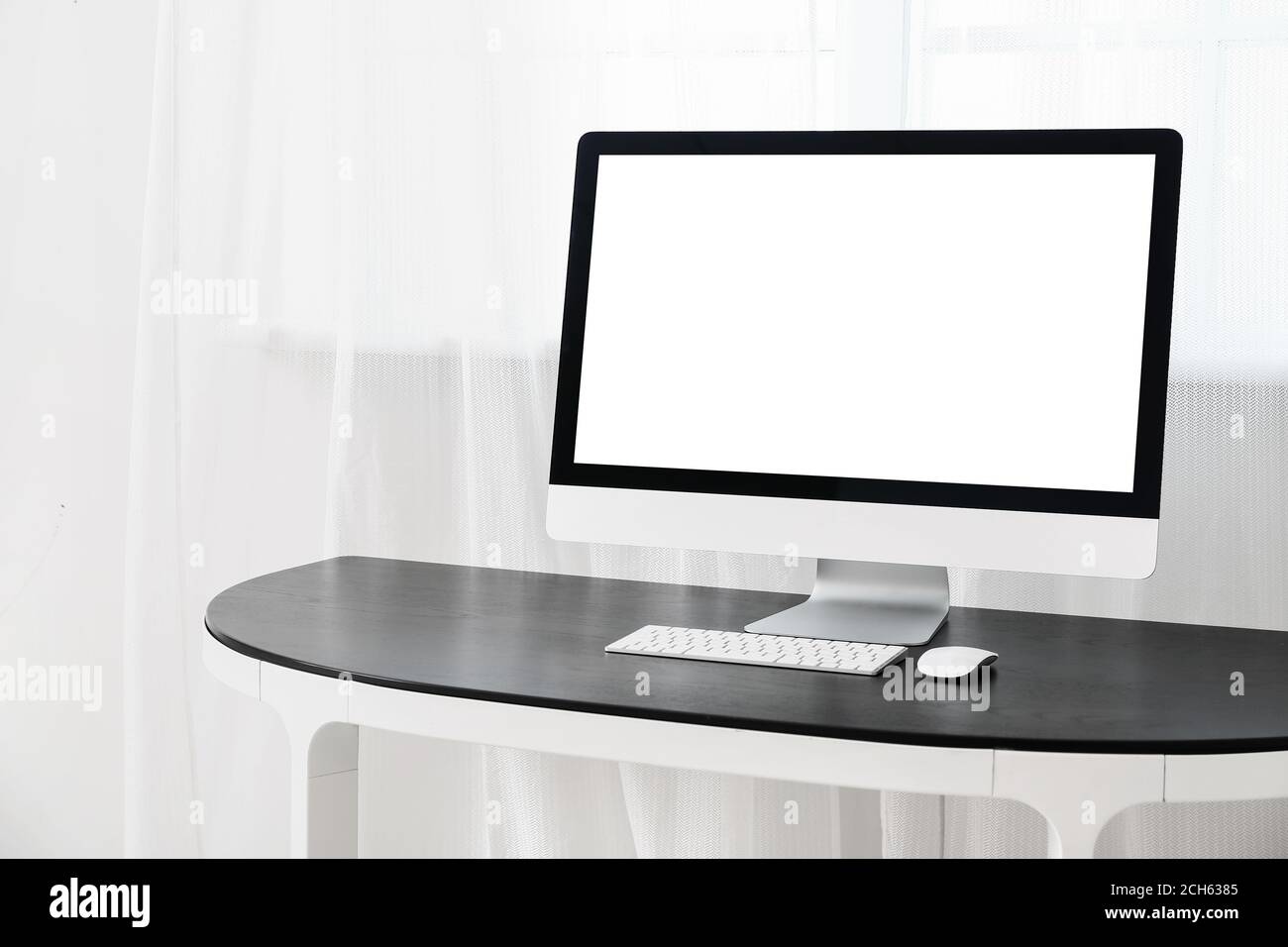 Modern PC monitor on table near window Stock Photo - Alamy