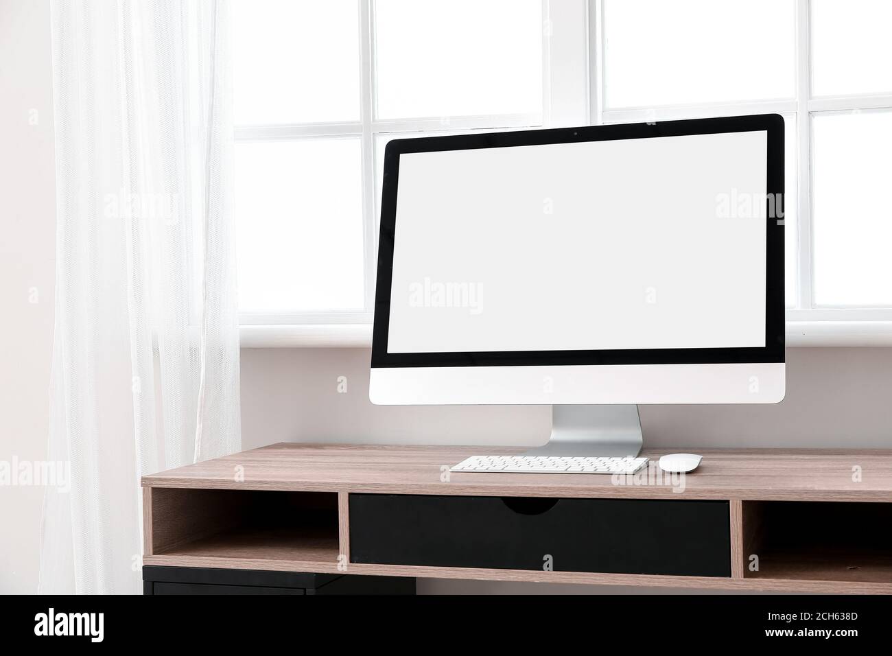 Modern PC monitor on table near window Stock Photo - Alamy