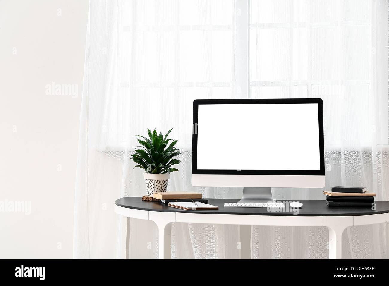 Modern PC monitor on table near window Stock Photo - Alamy