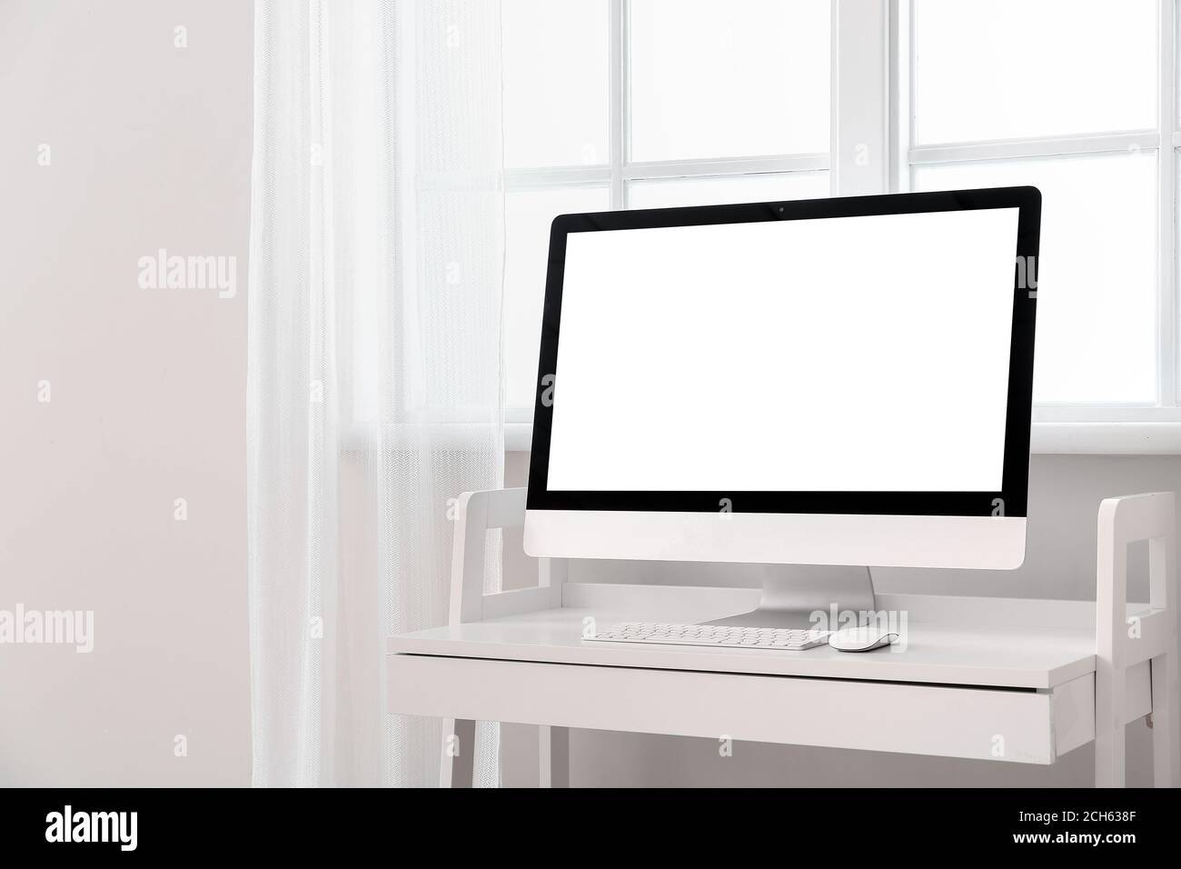 Modern PC monitor on table near window Stock Photo - Alamy
