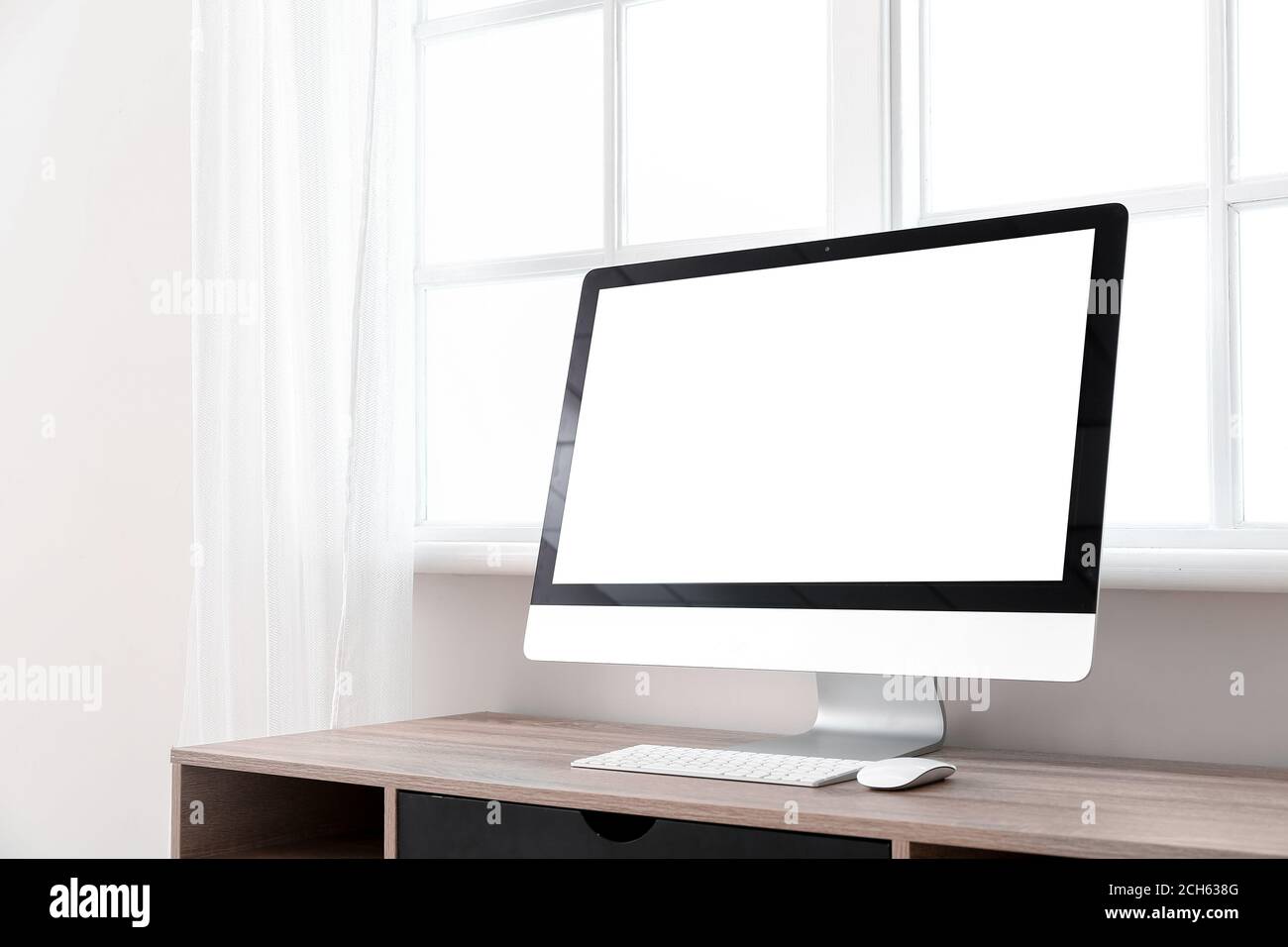 Modern PC monitor on table near window Stock Photo - Alamy