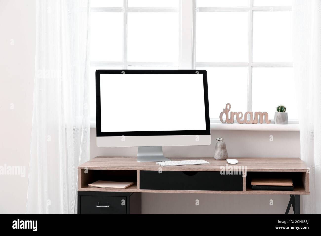 Modern PC monitor on table near window Stock Photo - Alamy