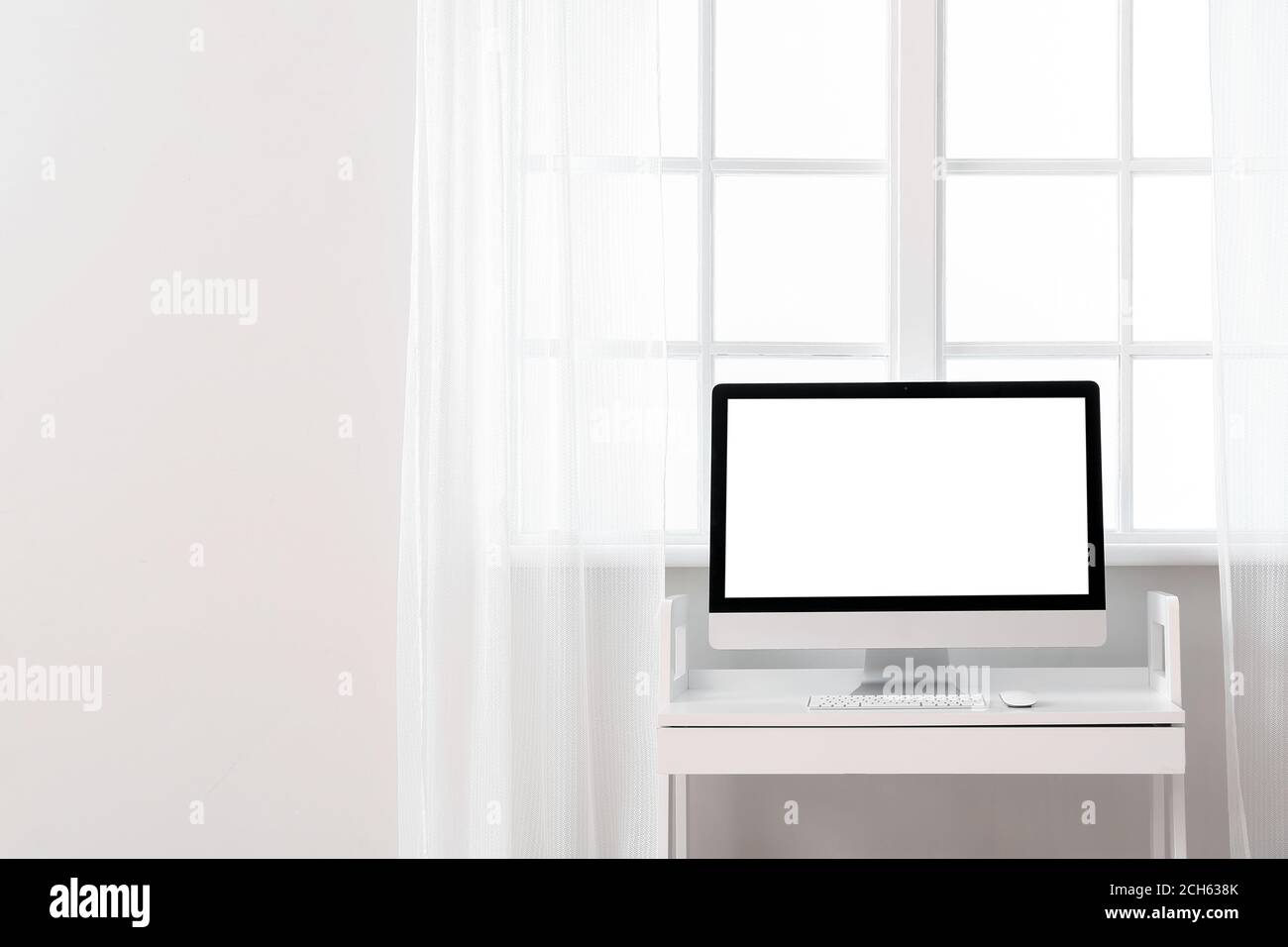 Modern PC monitor on table near window Stock Photo - Alamy