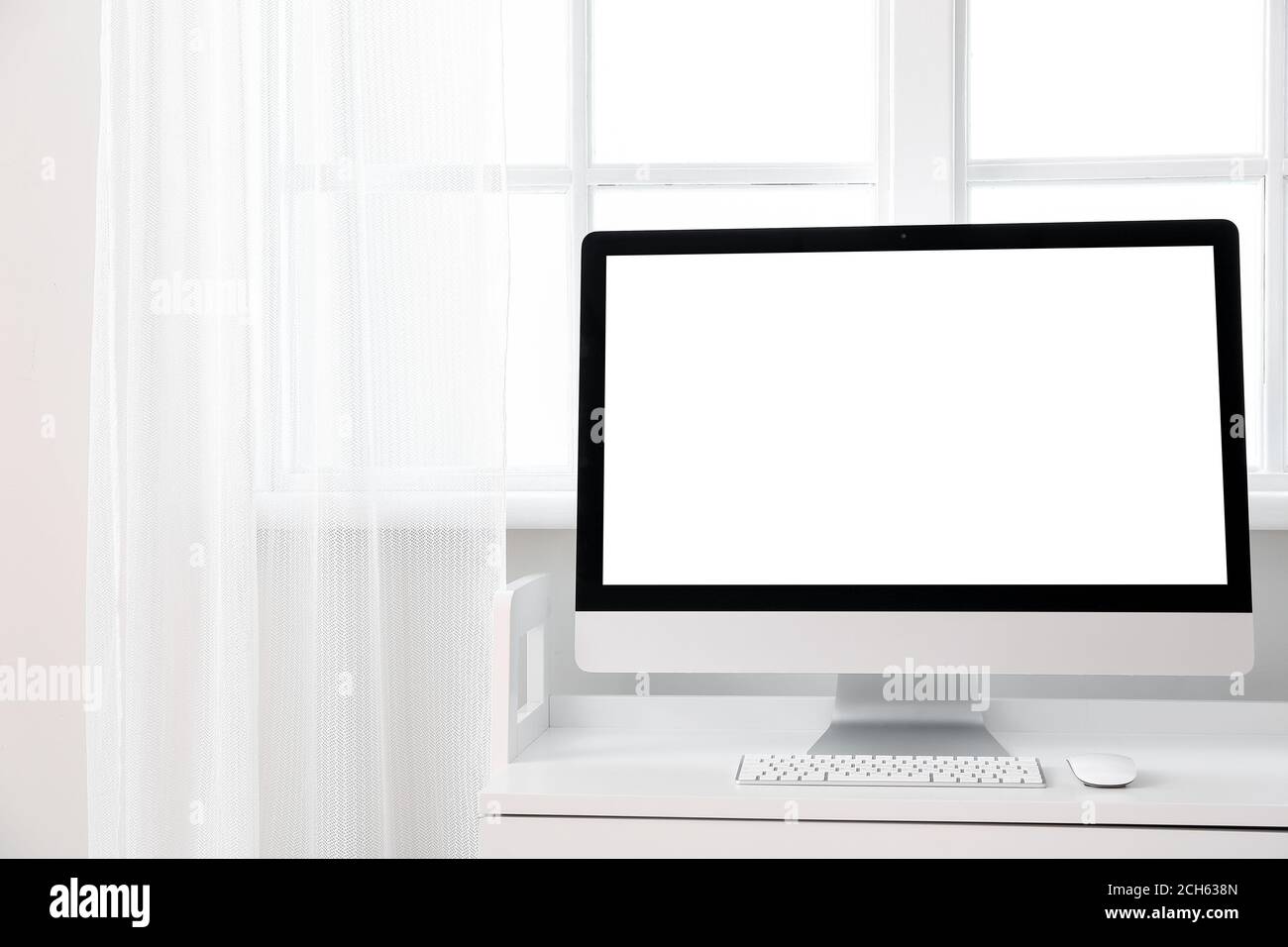 Modern PC monitor on table near window Stock Photo - Alamy